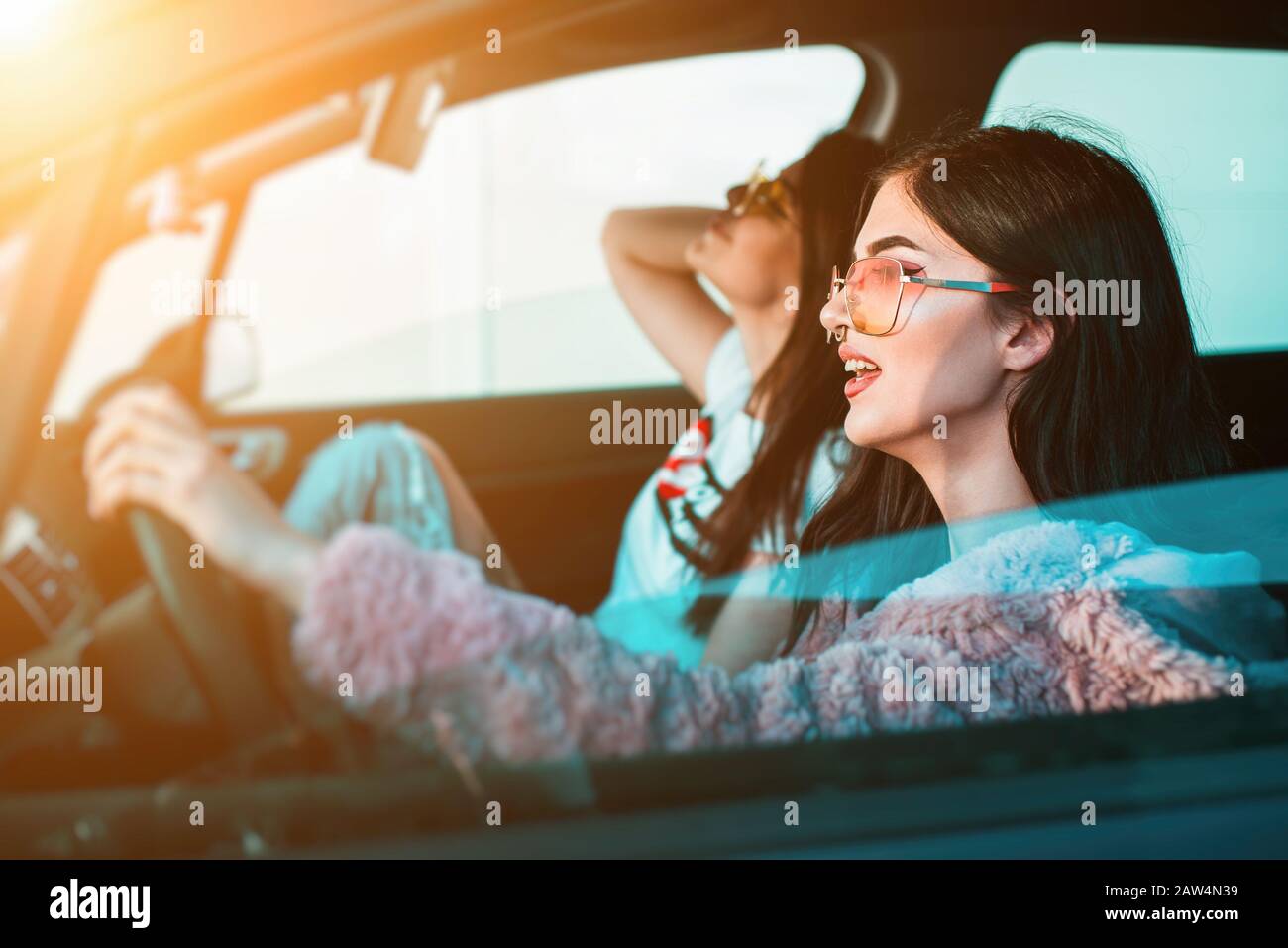 Two young modern woman having fun driving a car Stock Photo - Alamy