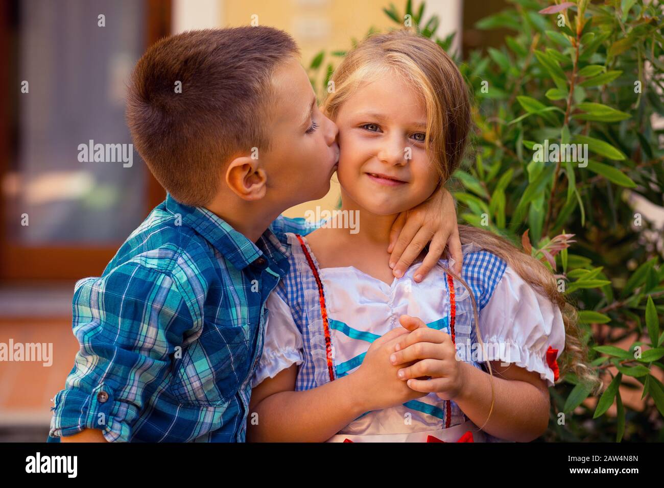 Brother boy are kissing his sister girl on the cheek, warm hugs in ...