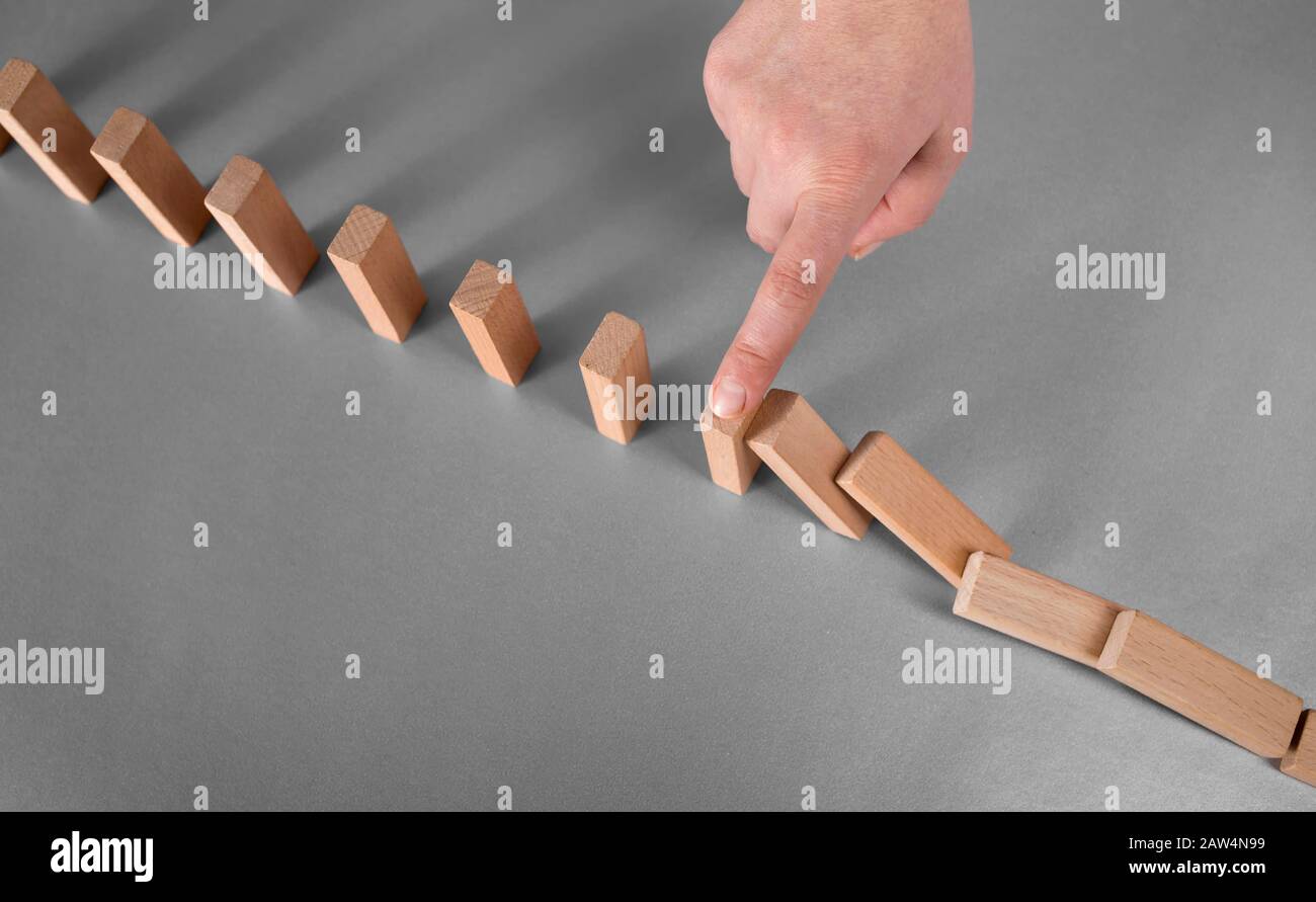domino effect prevention concept. finger stops falling dominoes Stock ...
