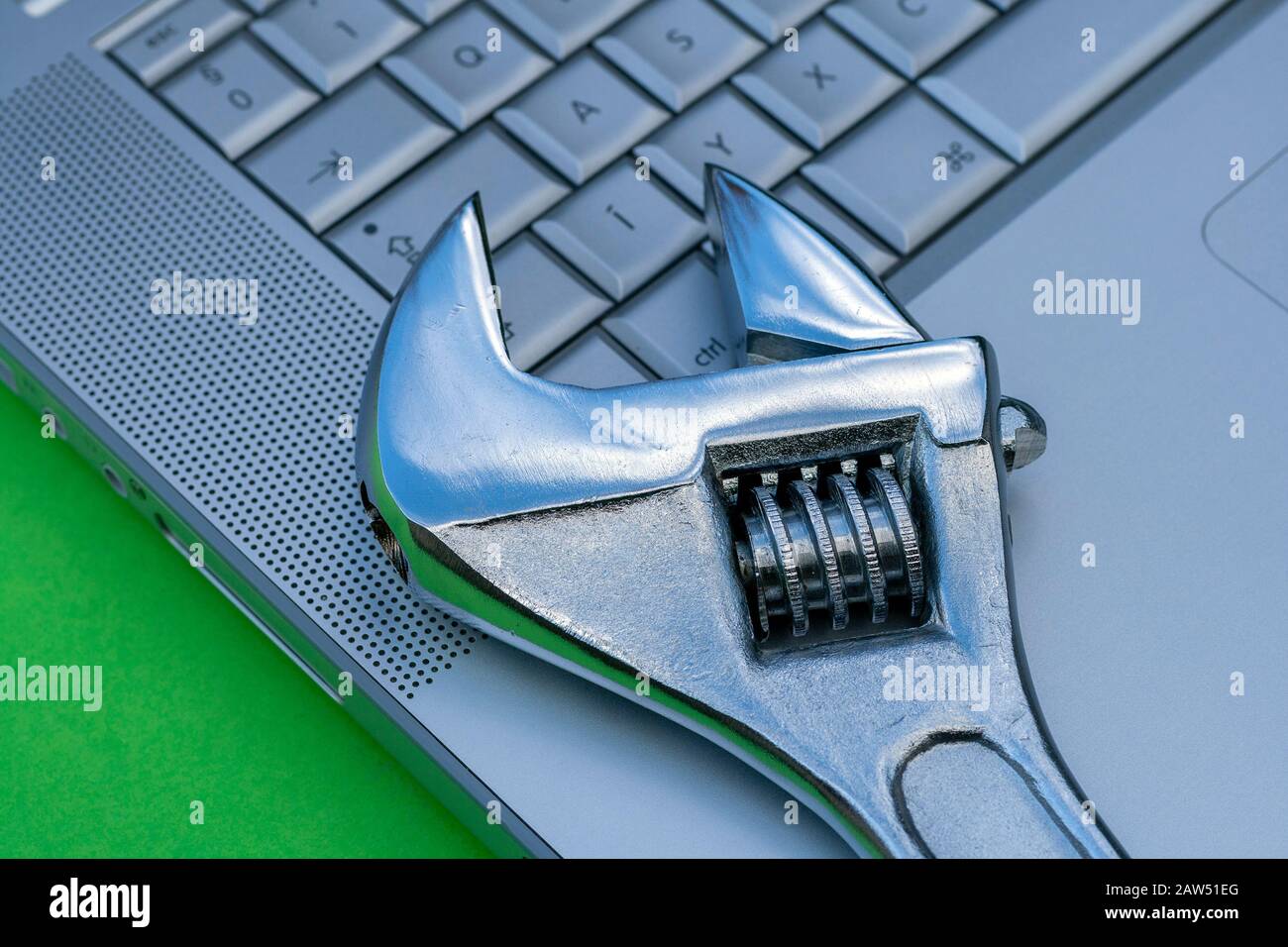 Adjustable wrench on a silver laptop. Computer service, maintenance ...