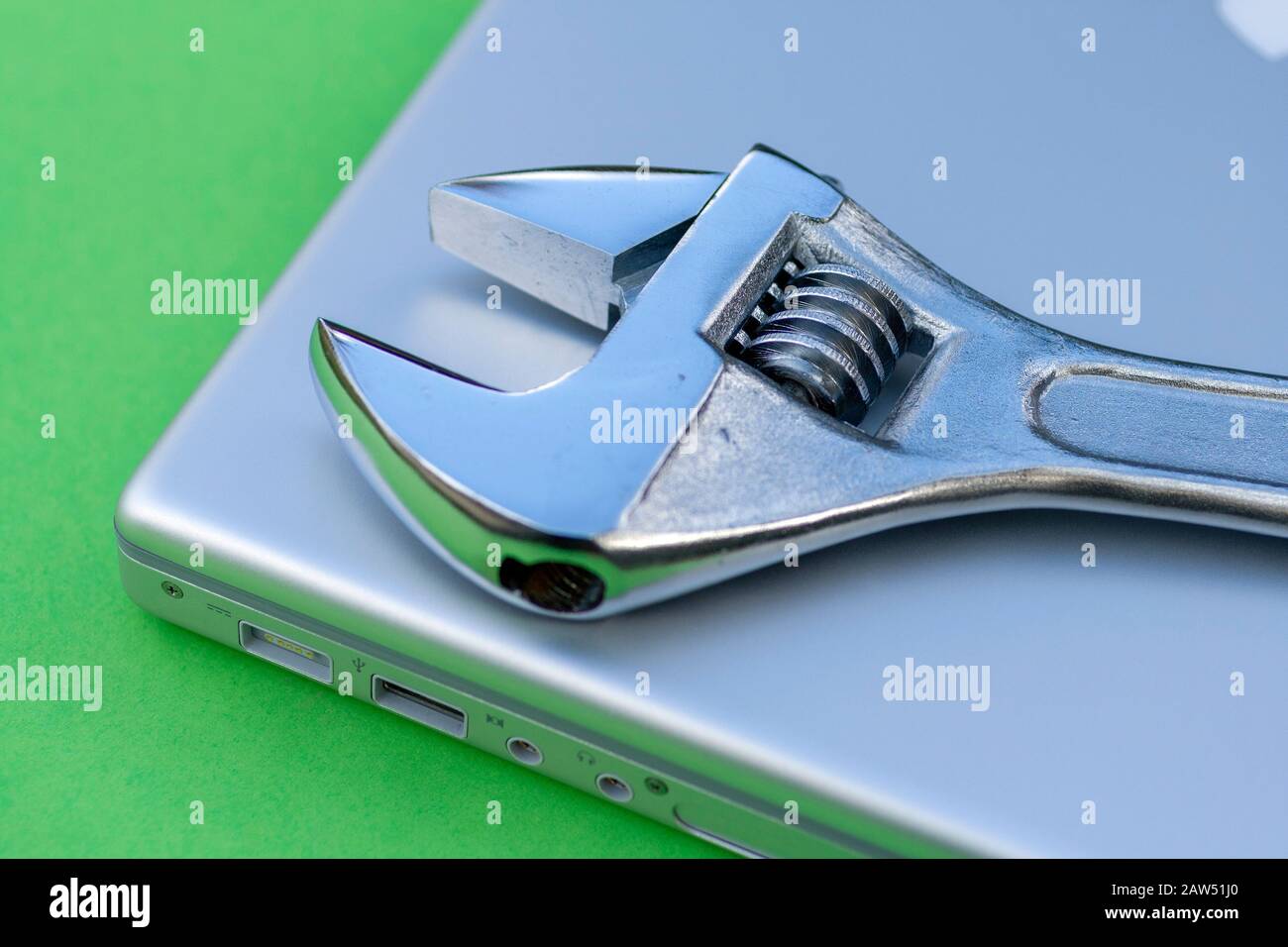 Adjustable wrench on a silver laptop. Computer service, maintenance ...