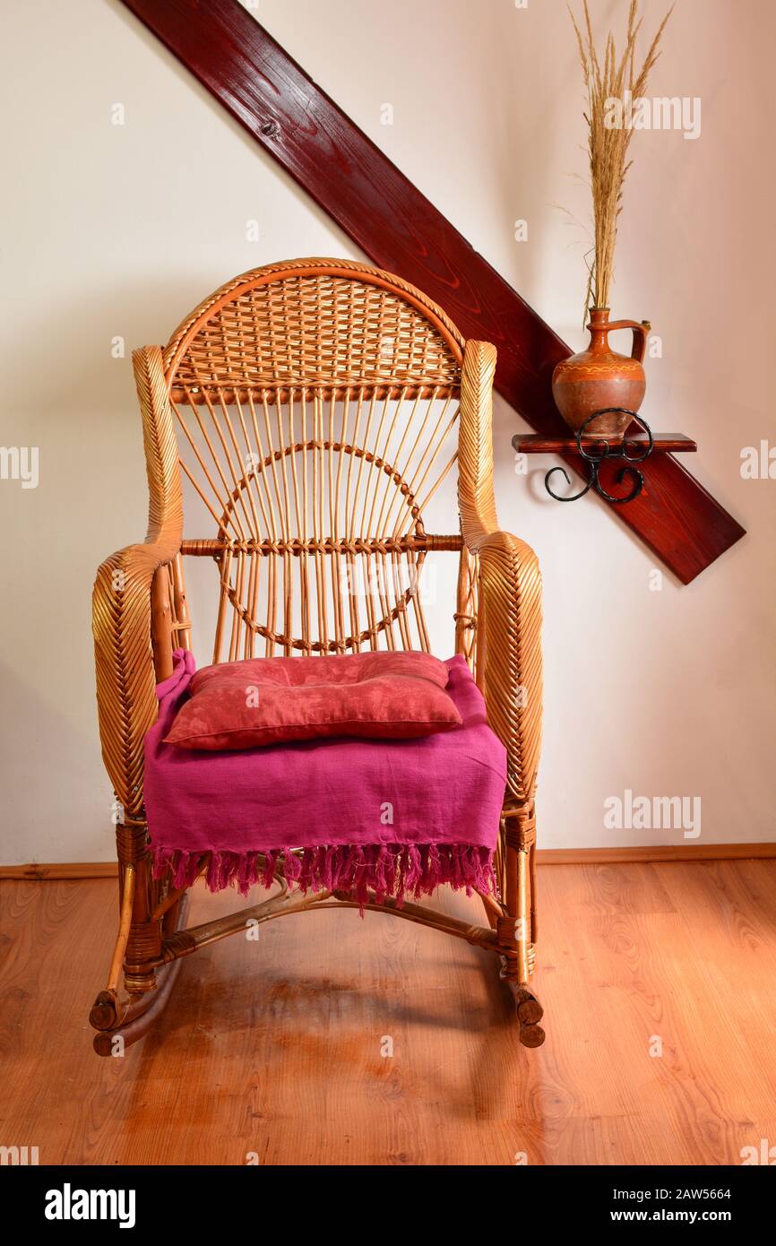 Wicker rocking chair on wooden parquet floor, as a part of interior of ...