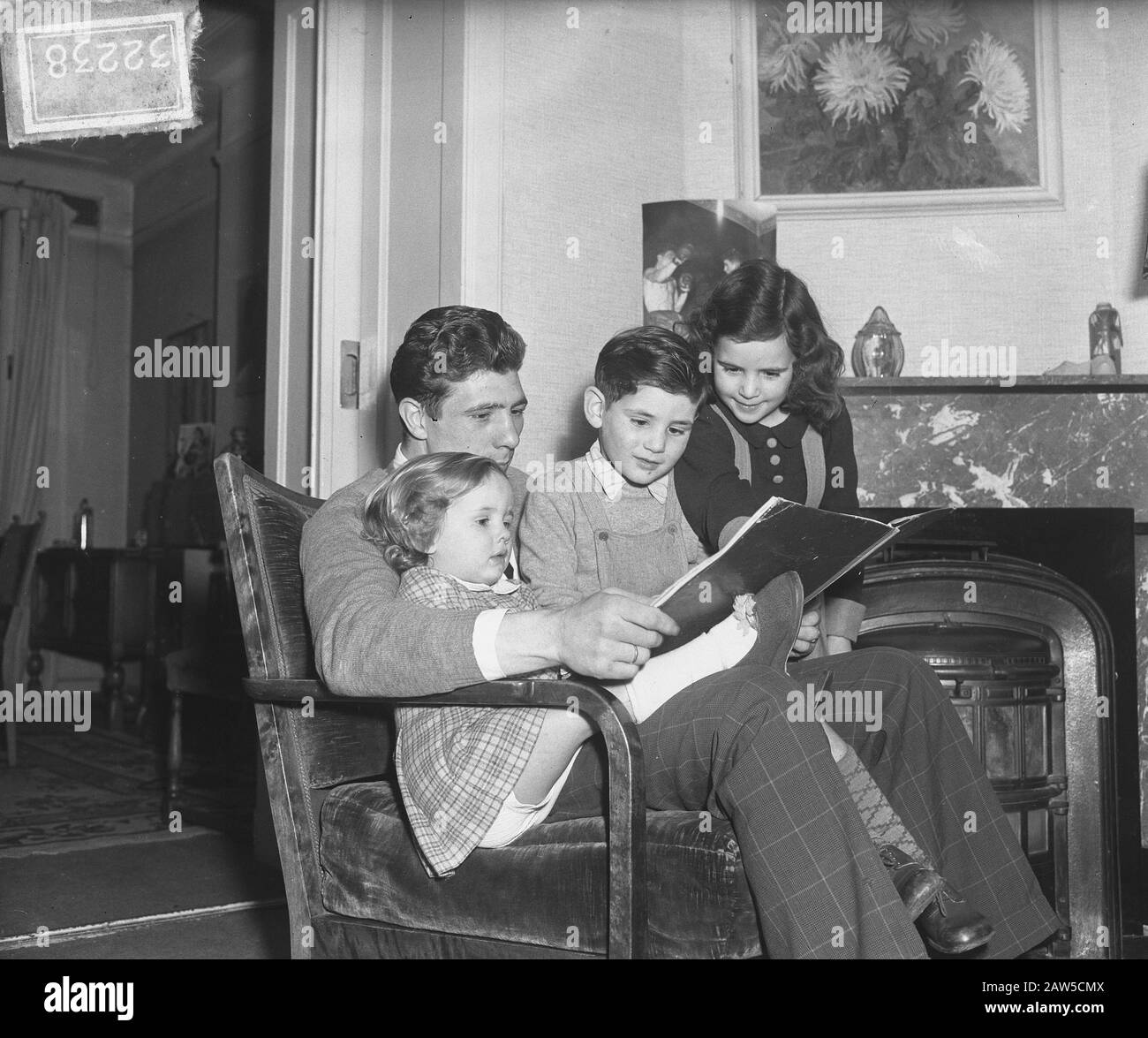 Luc Van Dam home [reads to children] Annotation: Luc van Dam was during the making of this photo ...