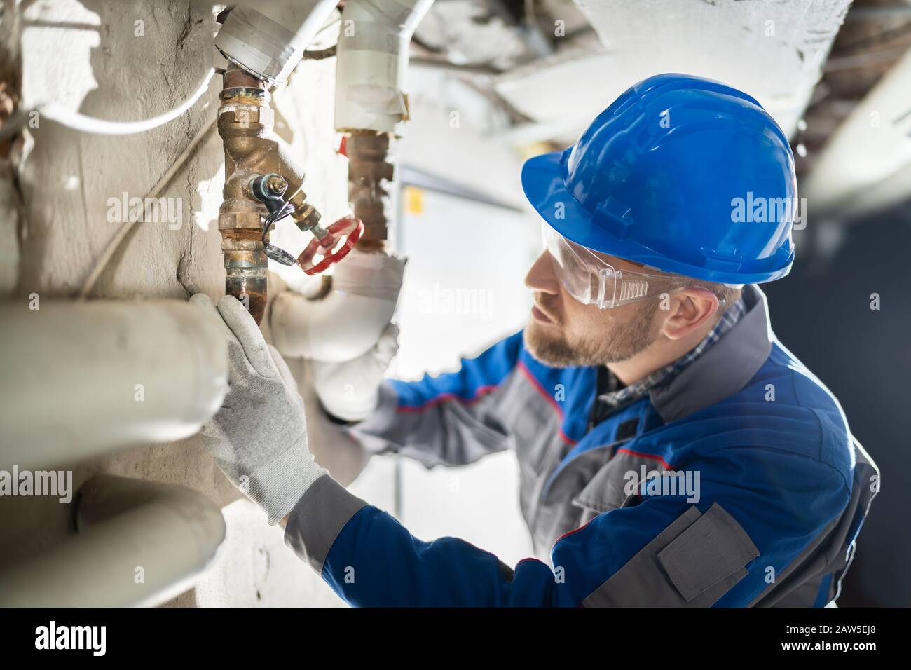 Male Worker Inspecting Water Valve For Leaks In Basement Stock Photo ...