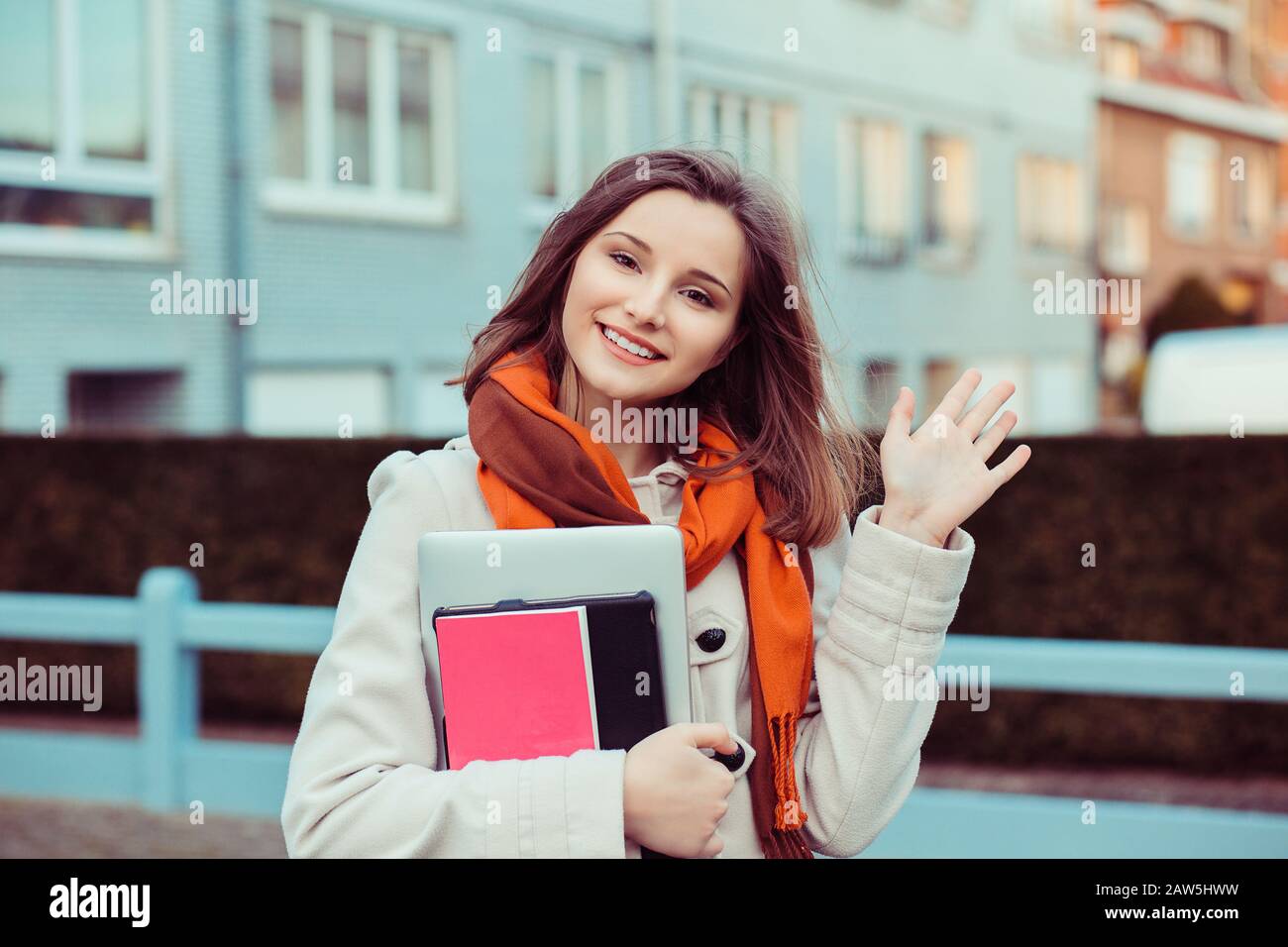 Happy student saying hi. Attractive young woman greeting a riend ...