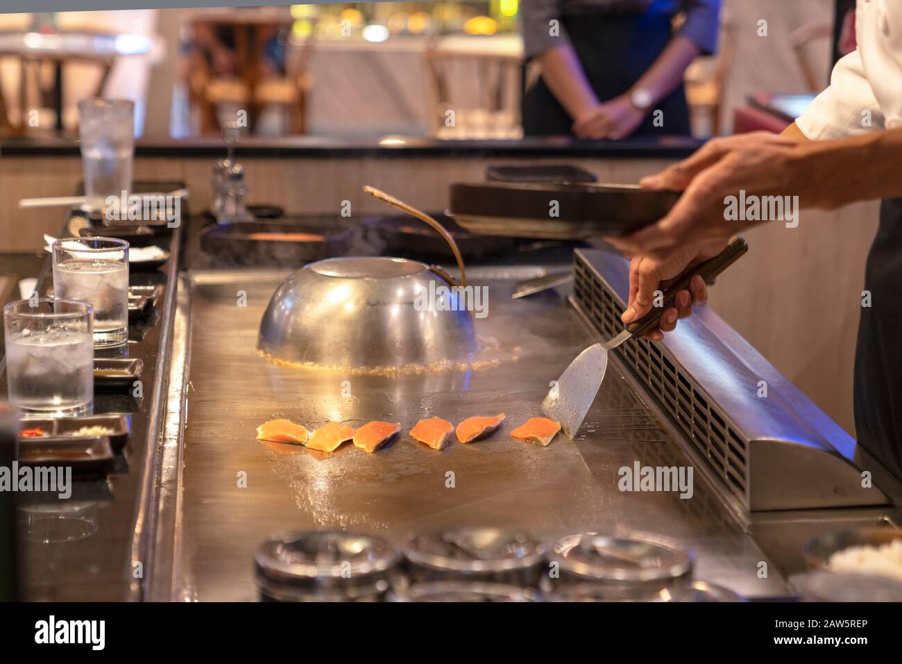 cooking and frying fish in a Japanese Tepanyaki pan. show for visitors ...