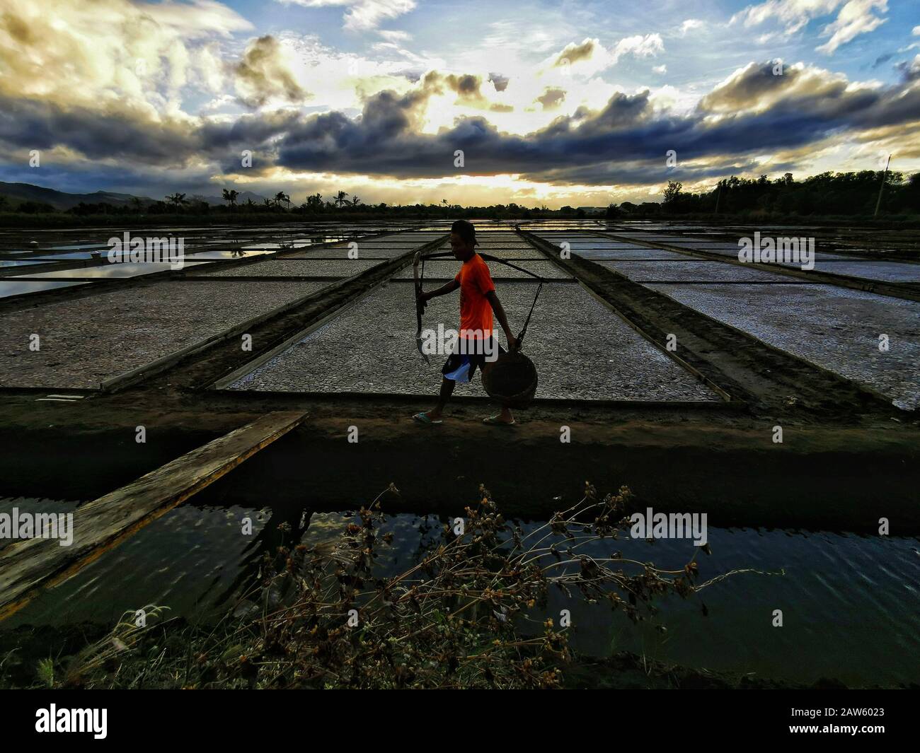 Philippines. 06th Feb, 2020. A farmer carries harvested salt at salt ...