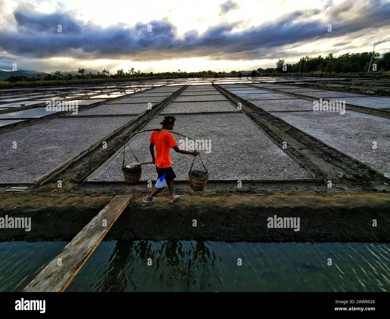 Philippines. 06th Feb, 2020. A farmer carries harvested salt at salt ...