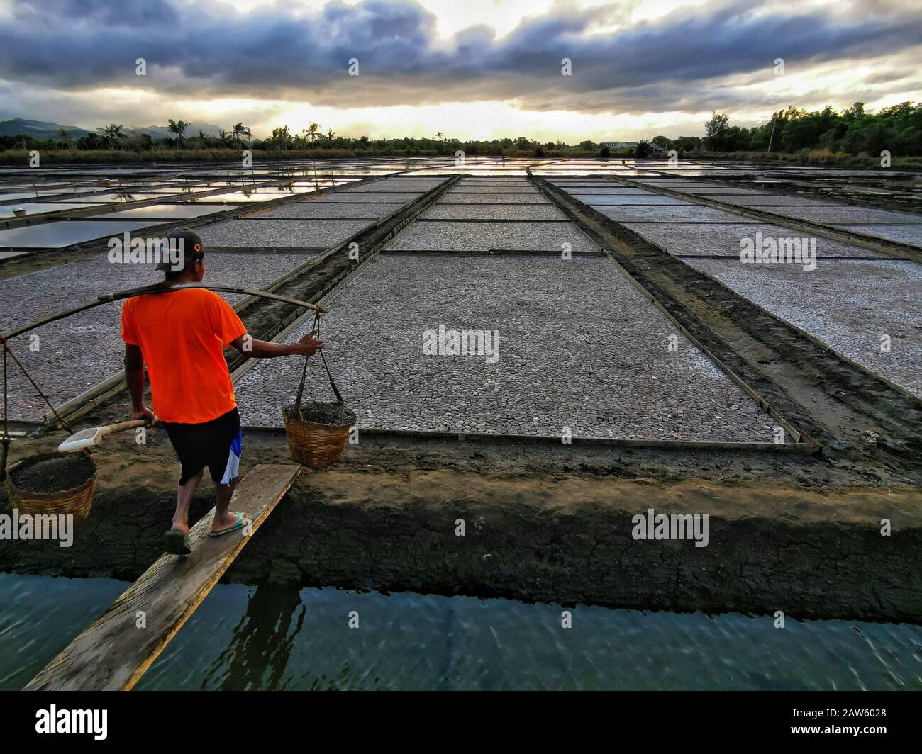 Philippines. 06th Feb, 2020. A farmer carries harvested salt at salt ...