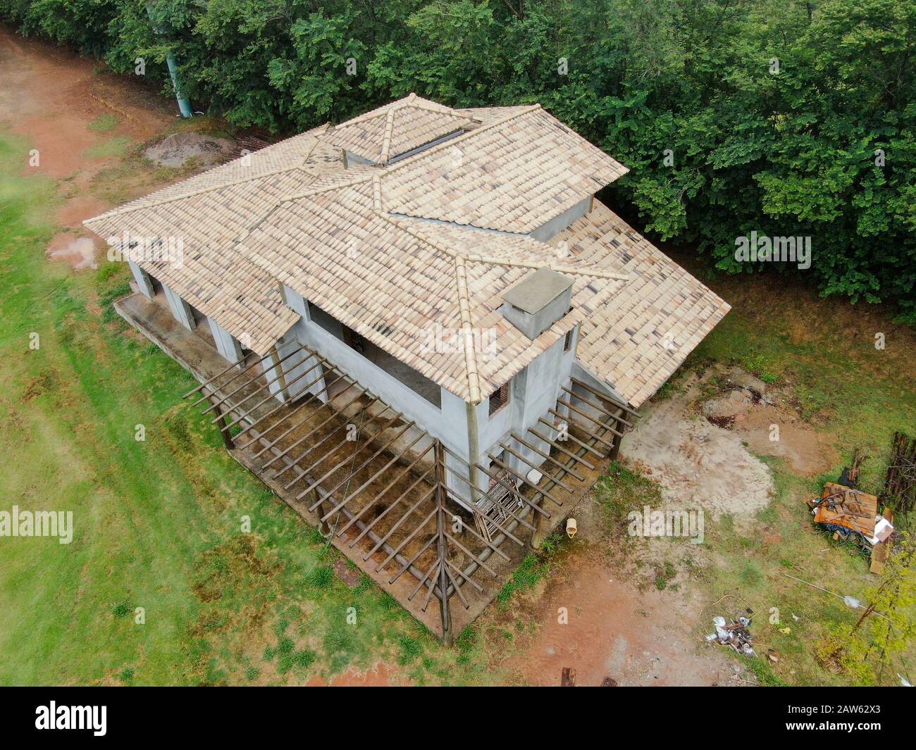 Aerial view of home type villa under construction surrounded by green ...