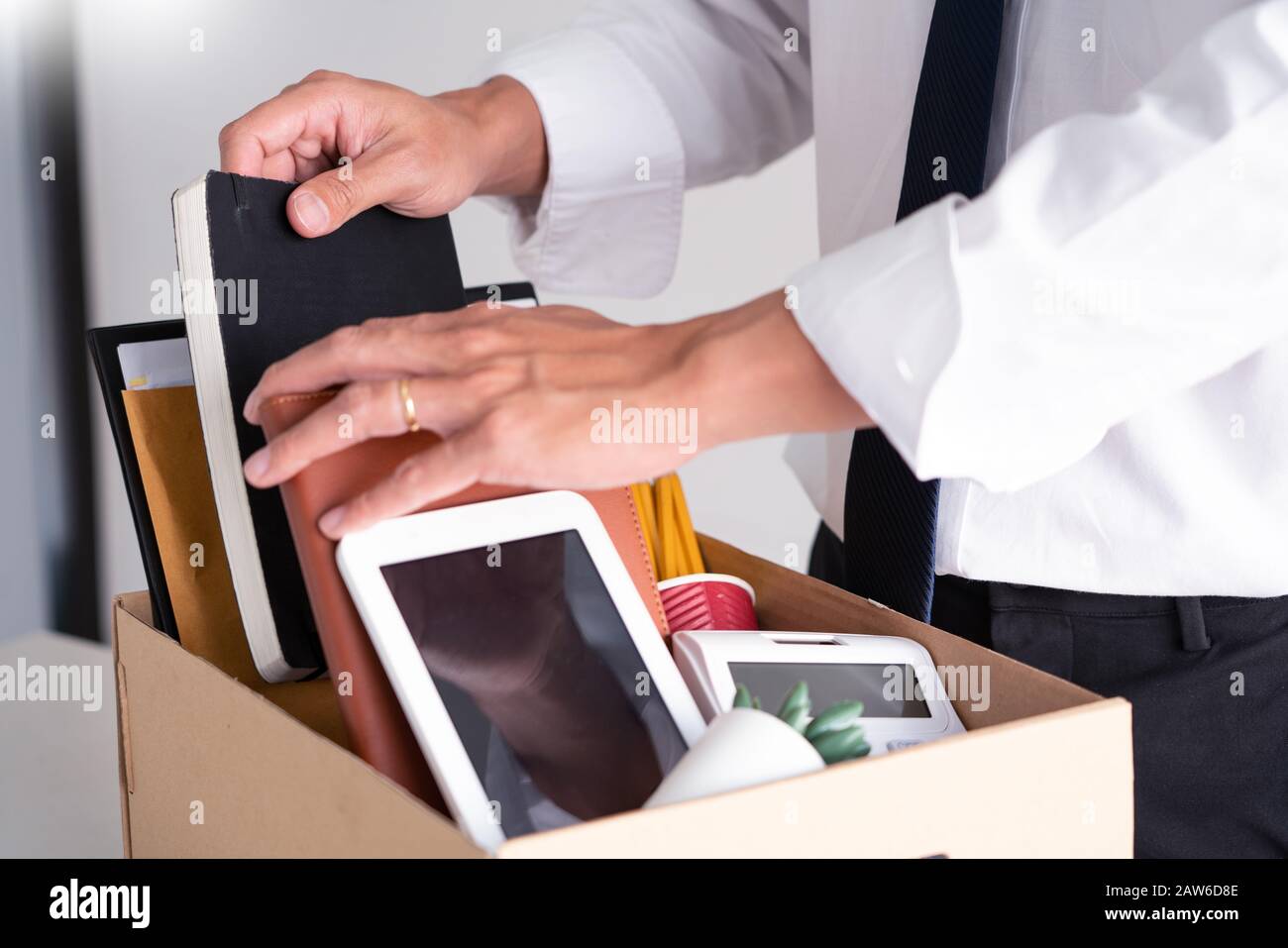 Sad Fired Young Employee businessmen hold boxes including pot plant and ...