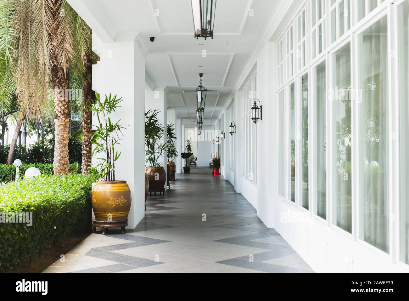 Beautiful interior of white corridors with lamps and green plants Stock ...