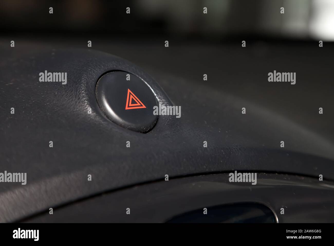 Close-up on emergency button with red triangle icon on the car ...