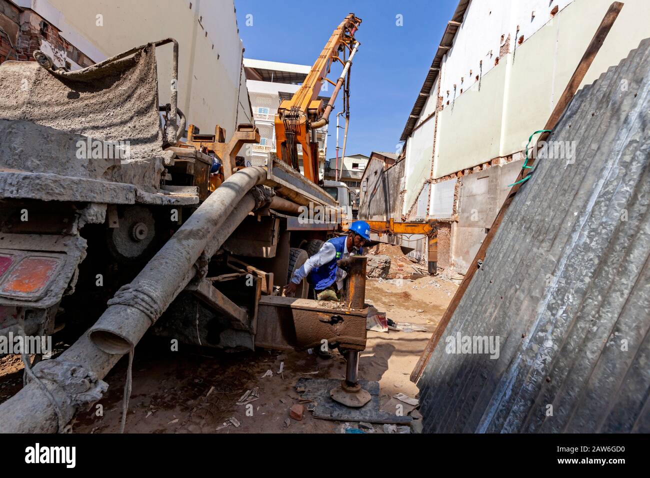 A small pile driver is set up on the construction site of a new ...