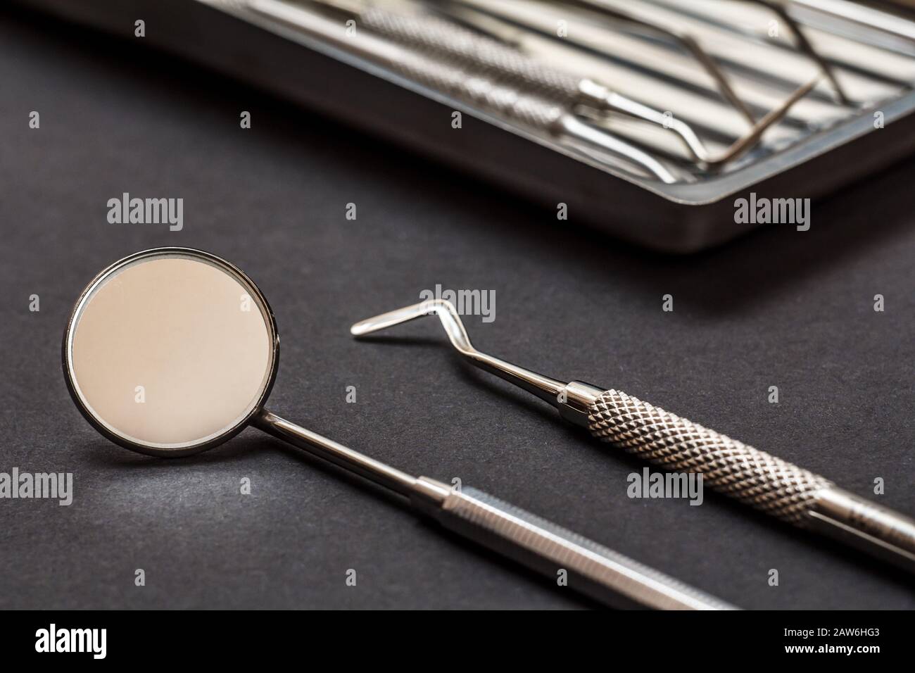 Set of metal instruments for dental treatment. Mouth mirror and tooth ...