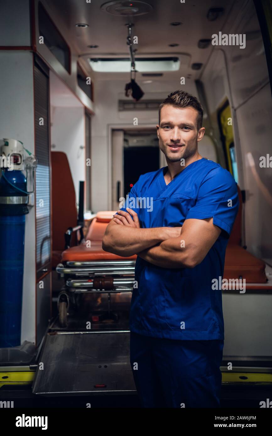 Smiling young corpsman in blue medical uniform stands over the ...