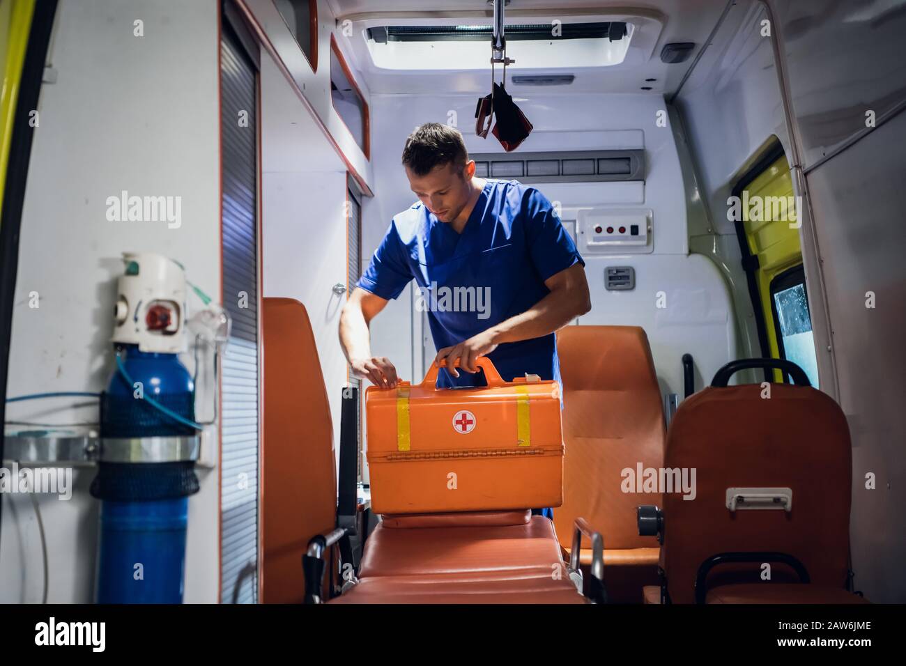 Young Paramedic In Blue Medical Uniform Packs Medical Bag In The