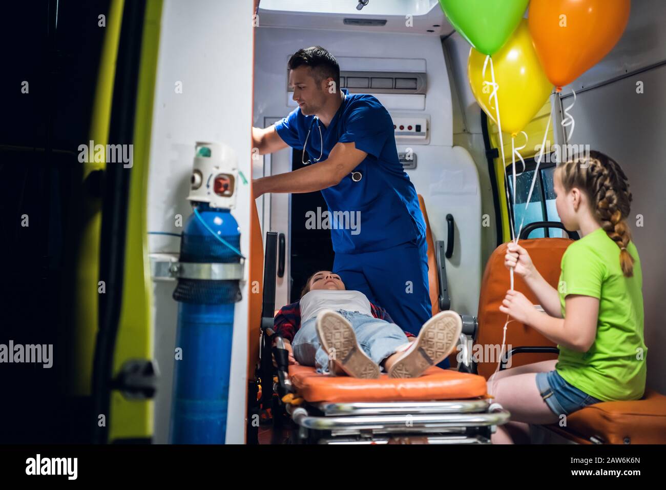 Ambulance car, corpsman in blue medical uniform and senseless woman ...