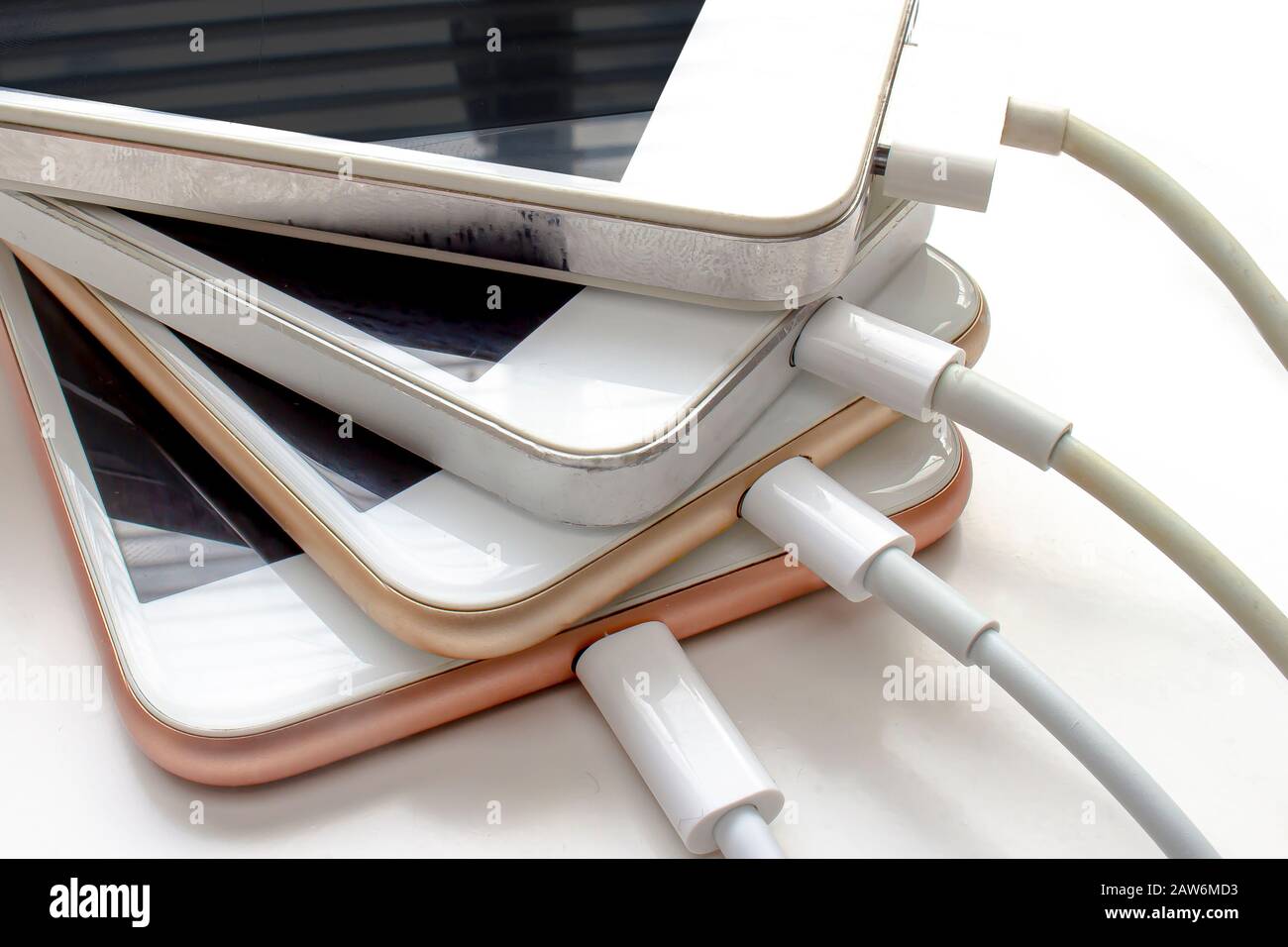 Mobile phones getting charger, electronic cable waste Stock Photo - Alamy