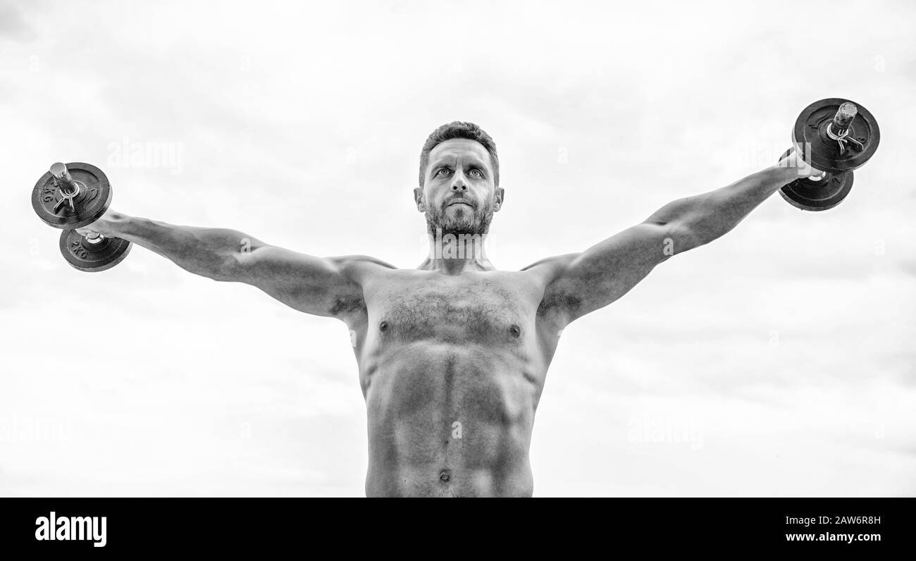 Healthy mind in healthy body. Muscular man exercising with dumbbell ...