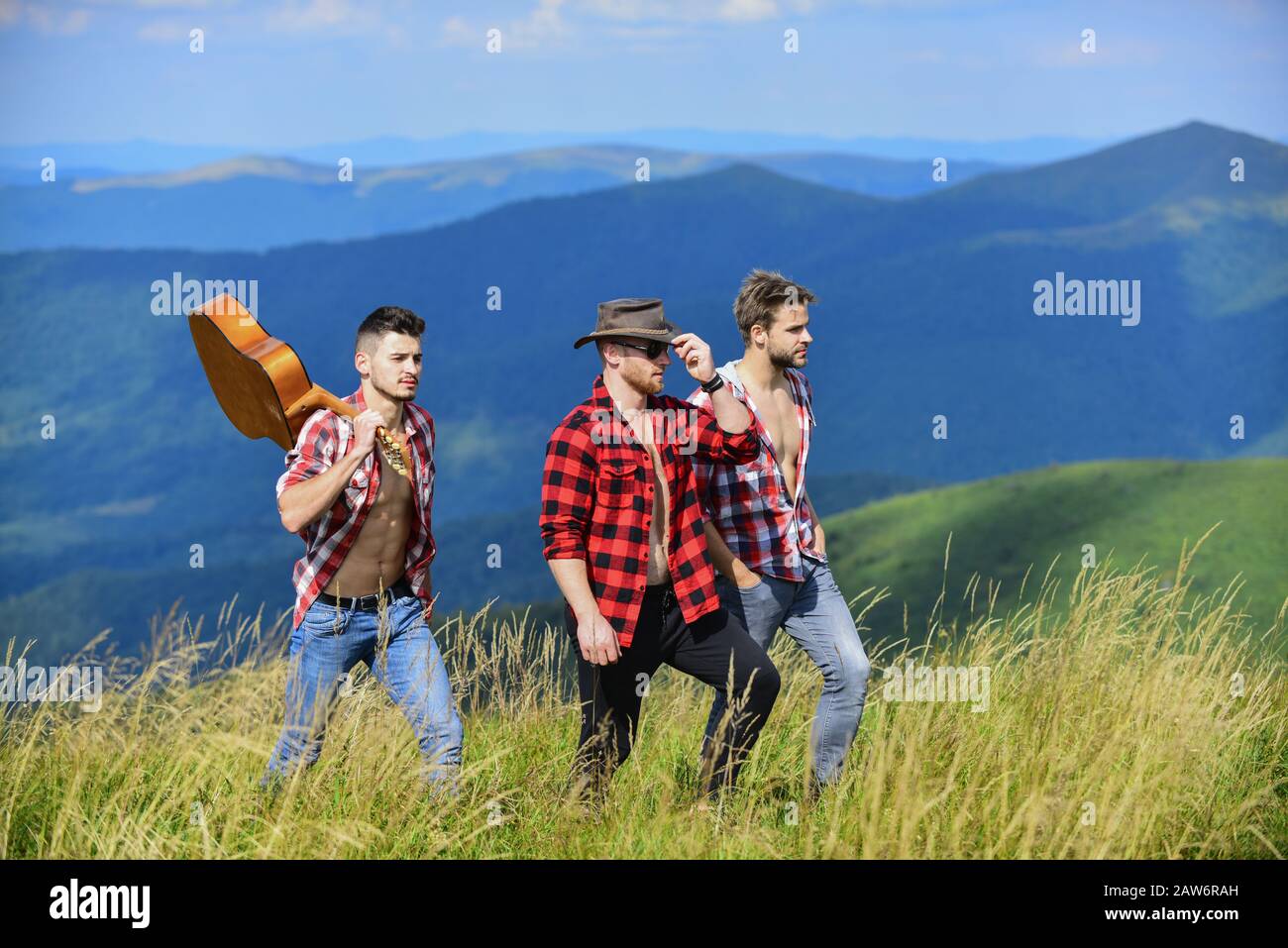 Men with guitar hiking on sunny day. Hiking with friends. Long route ...