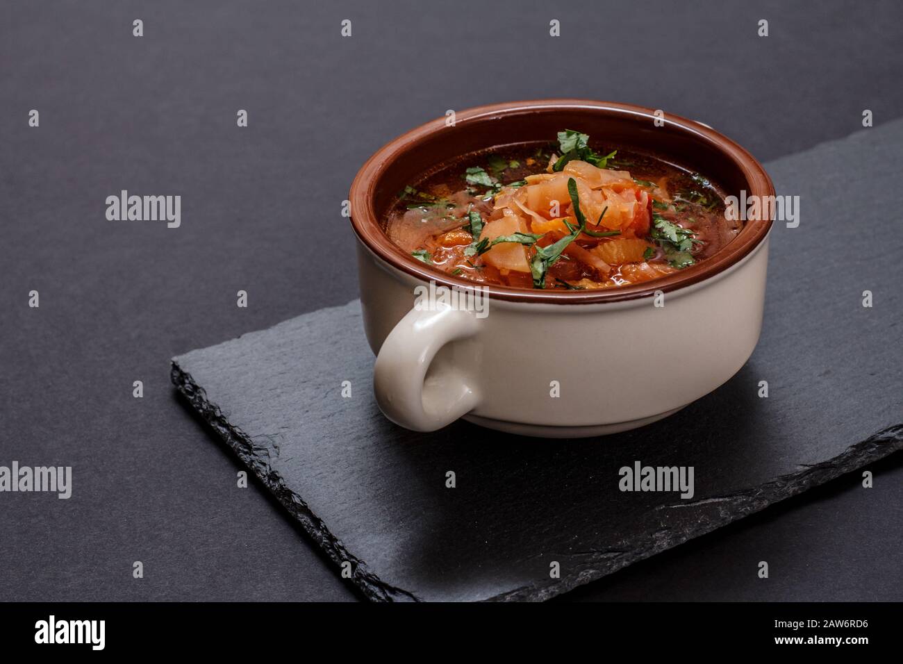 Ukrainian traditional borsch in porcelain bowl on stone board in black ...