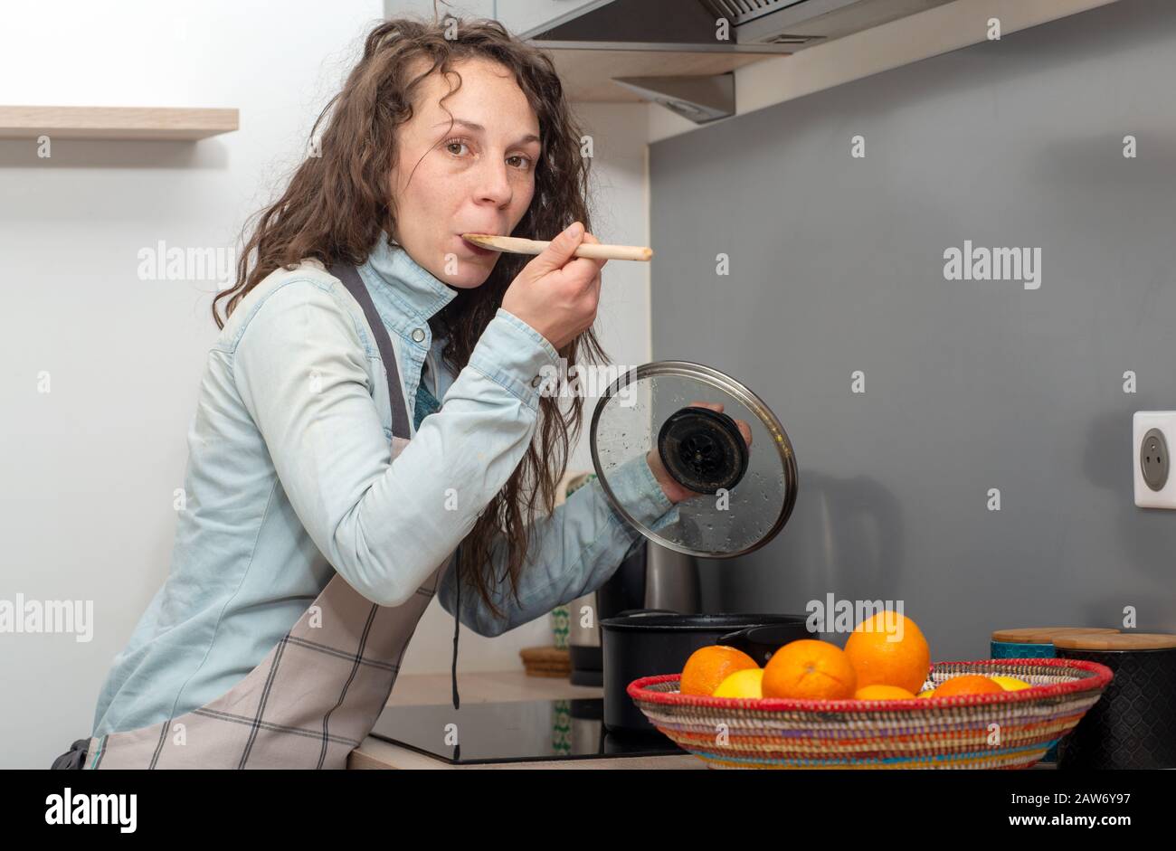 a young woman with long hair is in the kitchen Stock Photo - Alamy