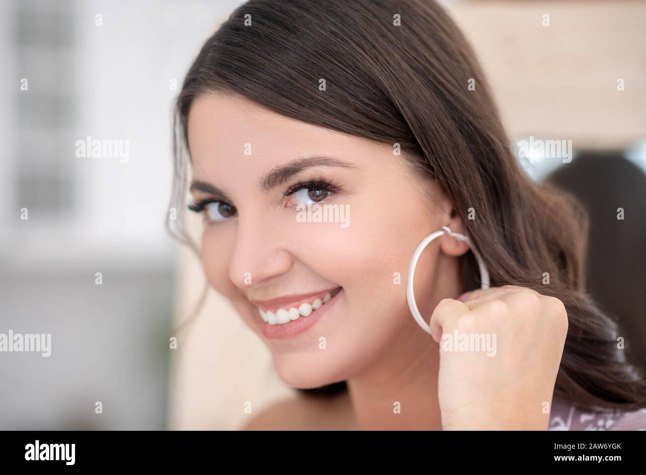Close up picture of oung pretty full-figured woman wearing big earrings ...