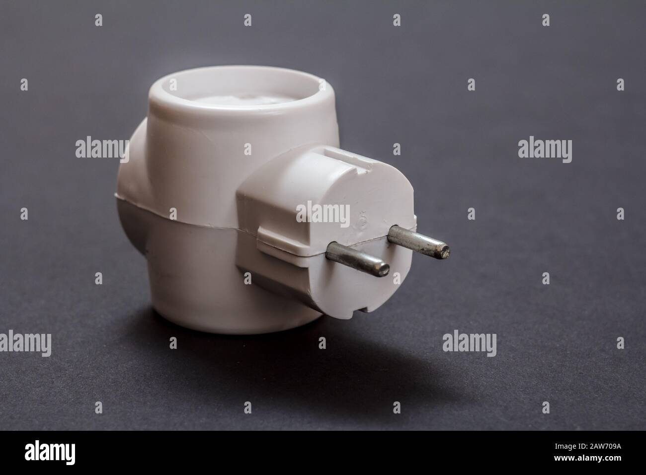 White electrical tee connector with three sockets on a black background ...
