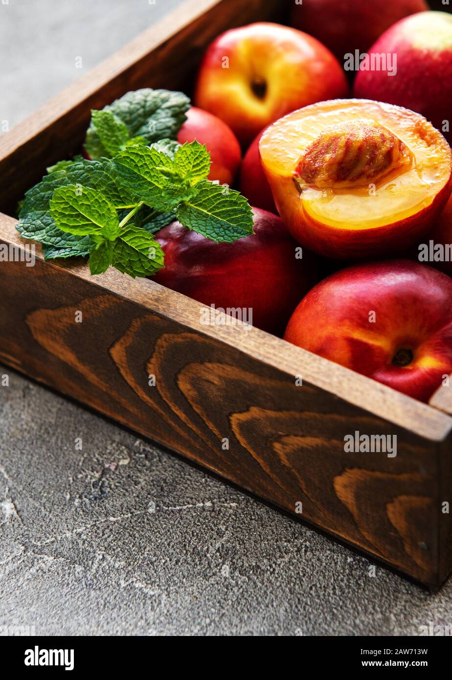 Box with fresh nectarines on a stone background Stock Photo - Alamy