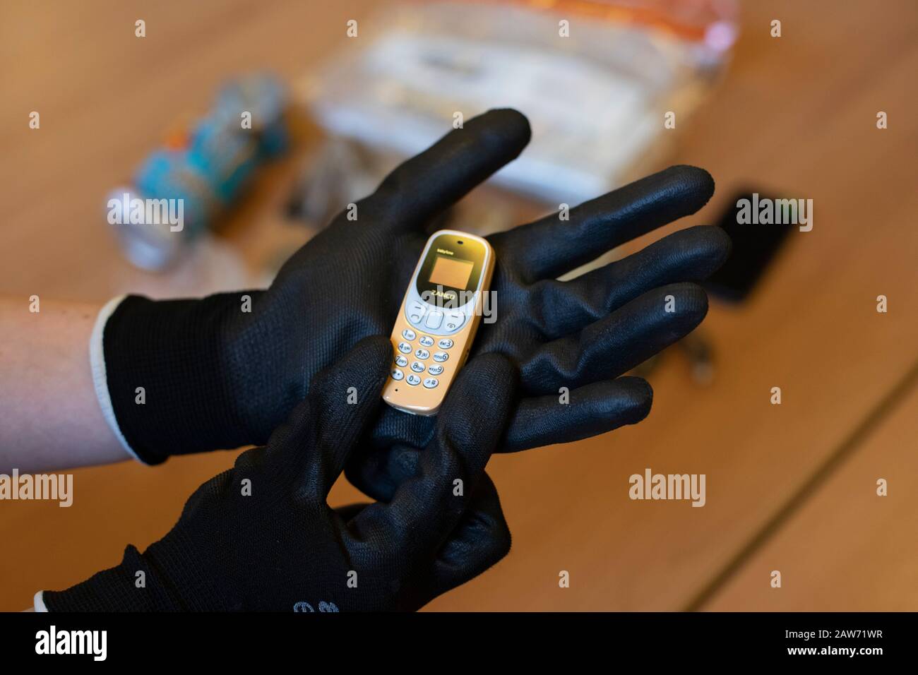 A prison officer examines a confiscated mobile phone used to smuggle ...
