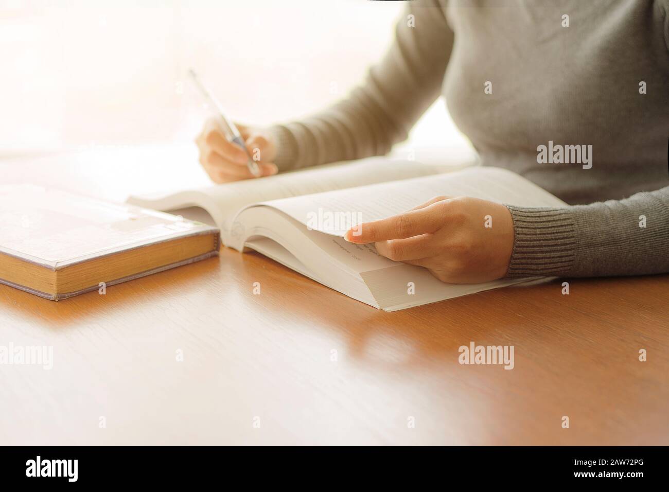 Close-up Asia woman writing paper at the desk with pen and reading ...