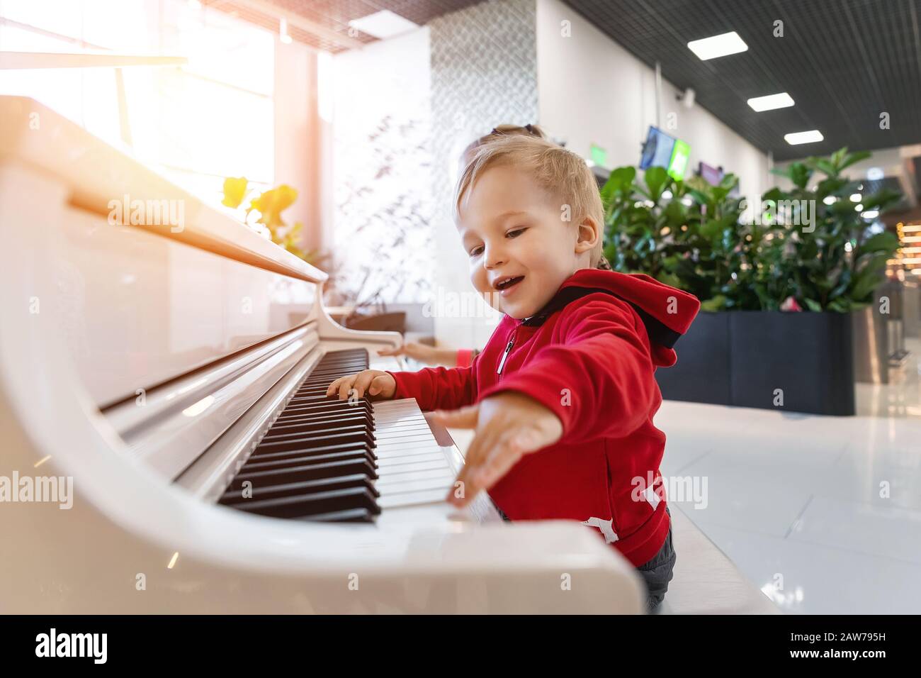 Blond boy playing piano hi-res stock photography and images - Alamy