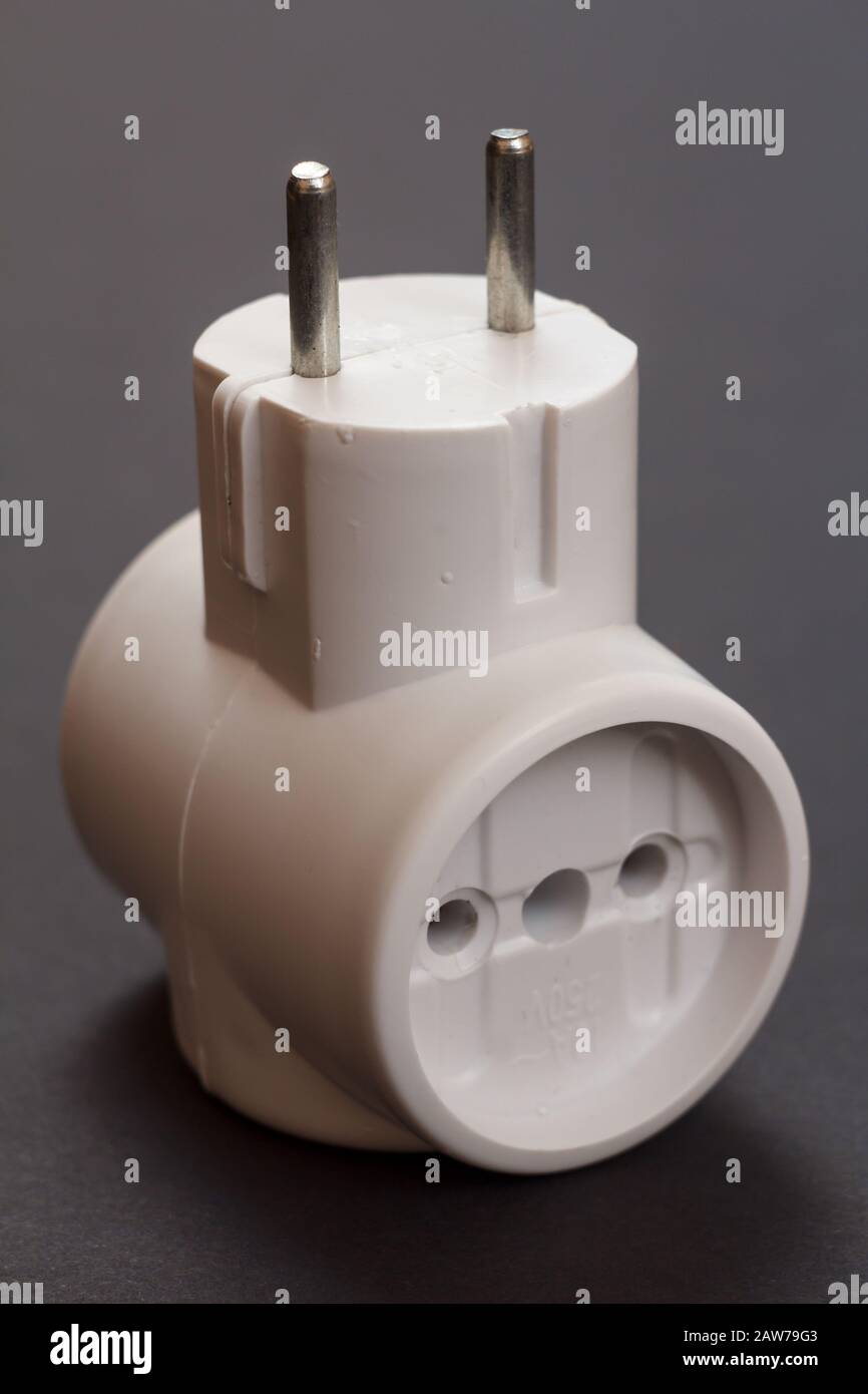 White plastic electrical tee connector with three sockets on a black ...
