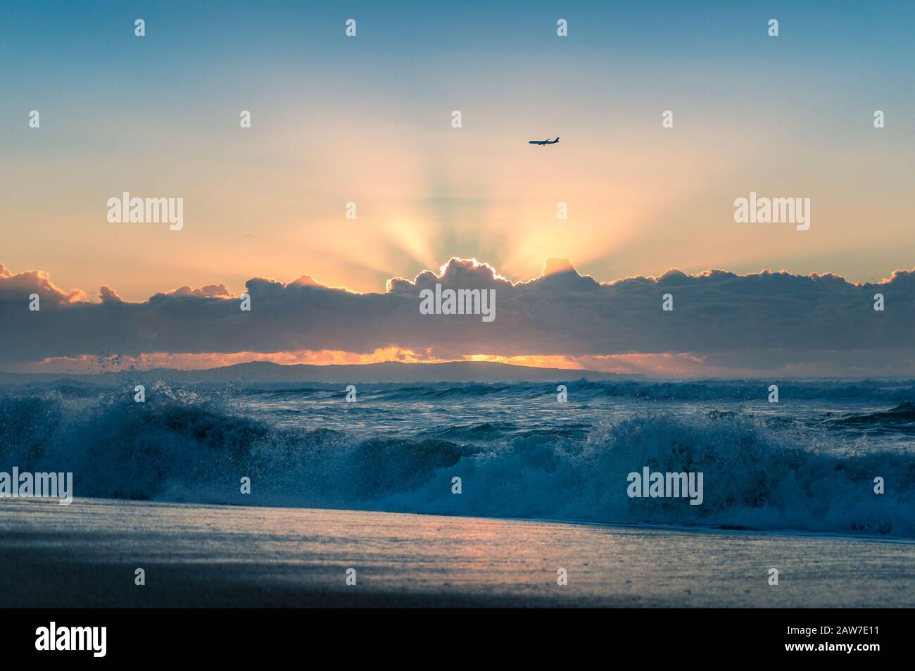 Epic sunrise seascape with god rays of sun beaming through the clouds ...