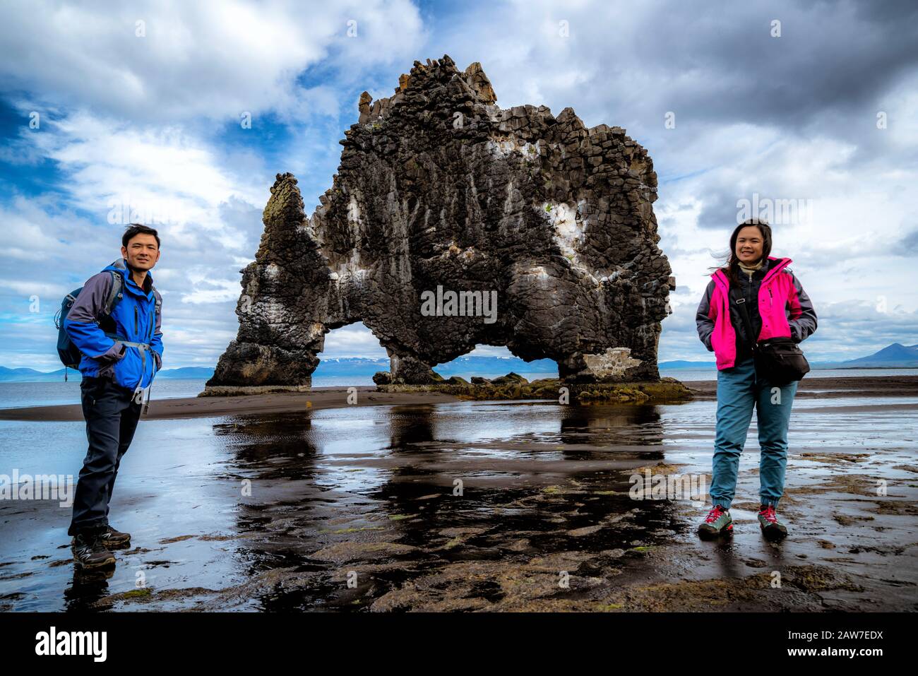 Traveler hiking to Hvitserkur, unique basalt rock landscape in Iceland ...