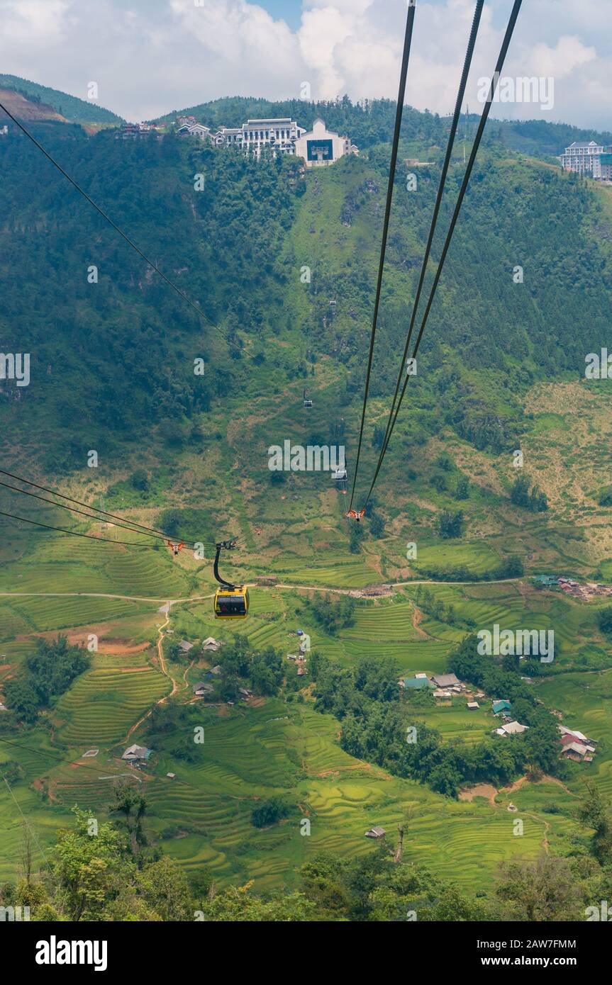 Cable car riding over green mountain valley with rice terraces. Travel ...