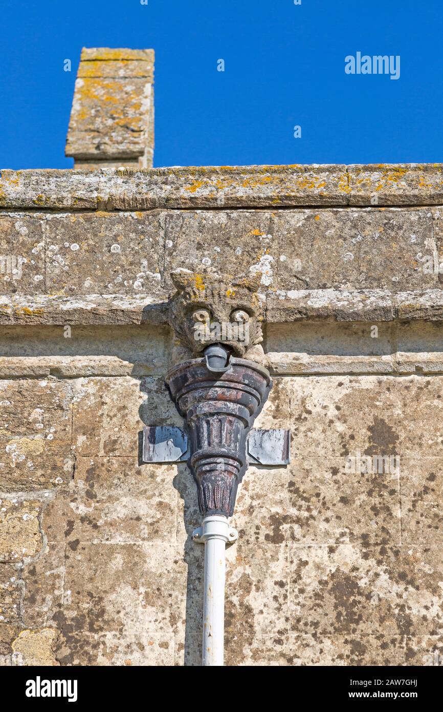 Gargoyle grotesque face drainpipe on wall medieval church of Saint John ...