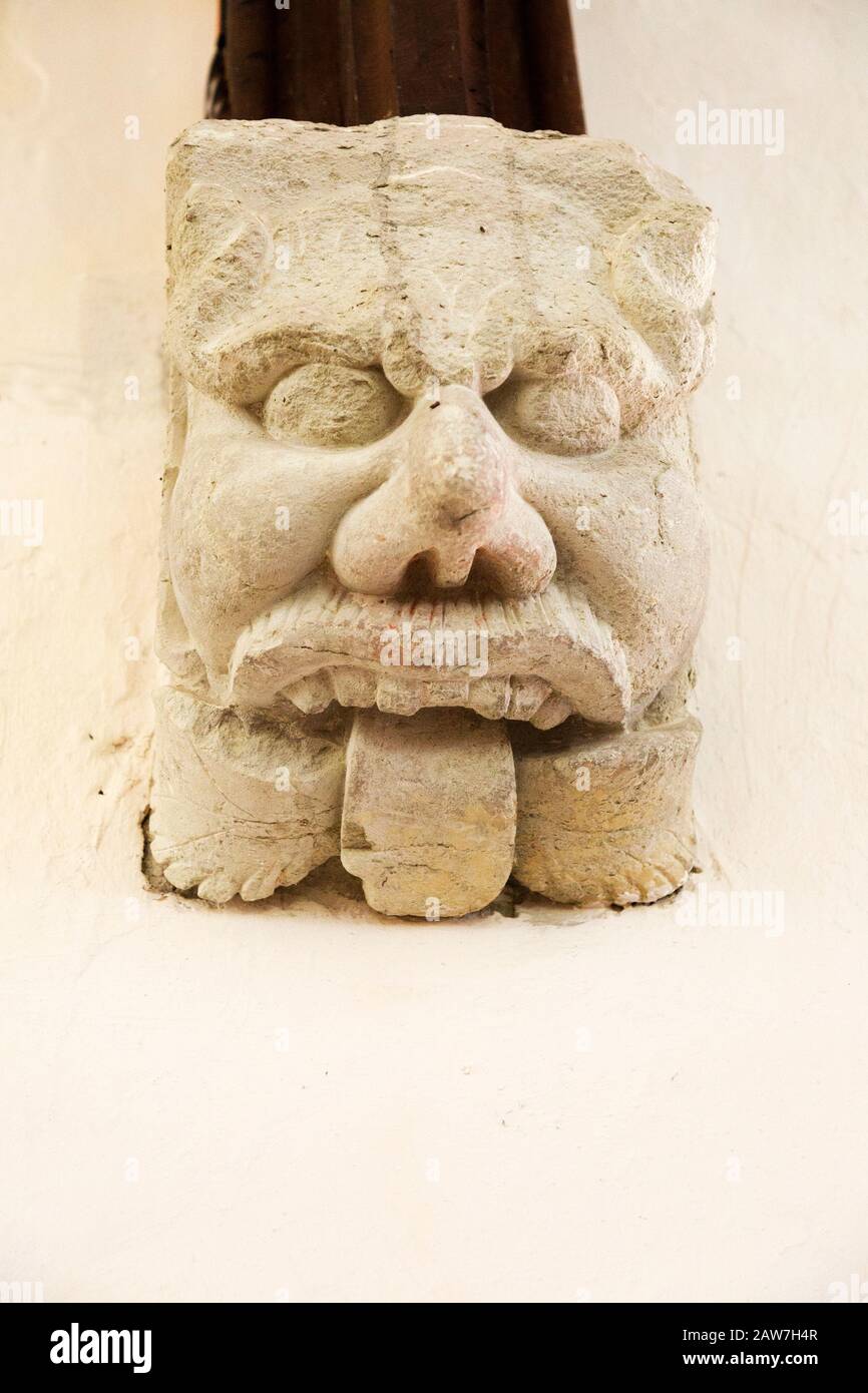 Grotesque corbel stone figure with mouth pulled open and rolling tongue ...