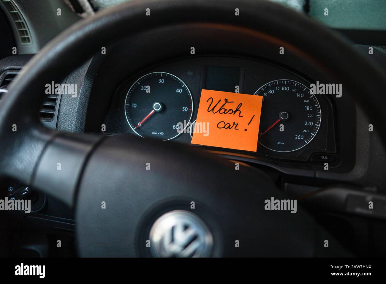 Writing wash car on memo post reminder. Text on sticky paper inside car ...