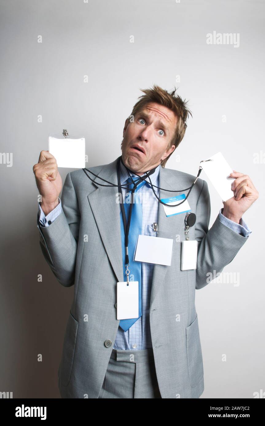 Confused office worker indundated with blank name tags looking up with ...