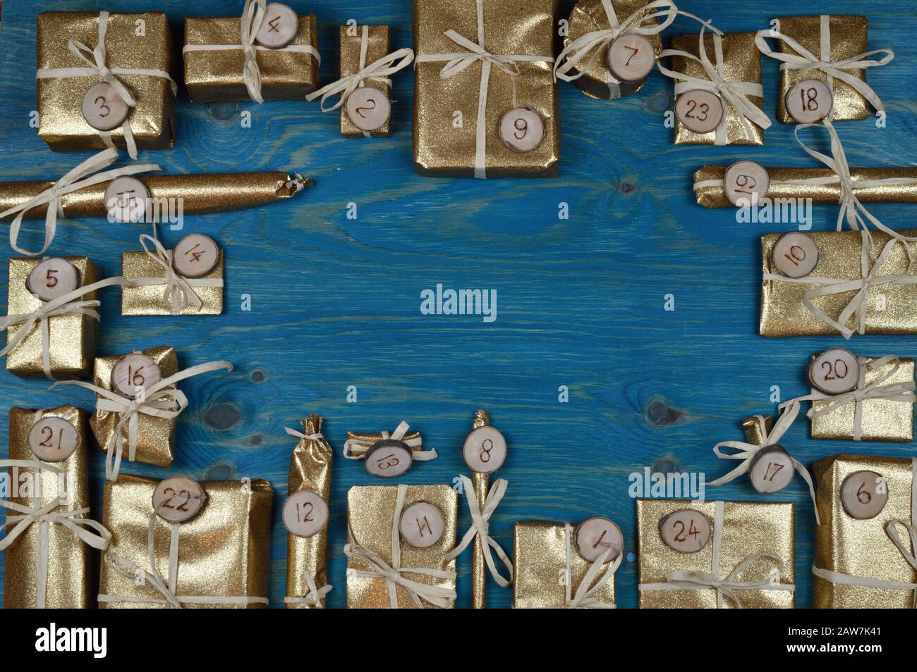 Frame of advent calendar with twenty four golden presents on teal wood ...