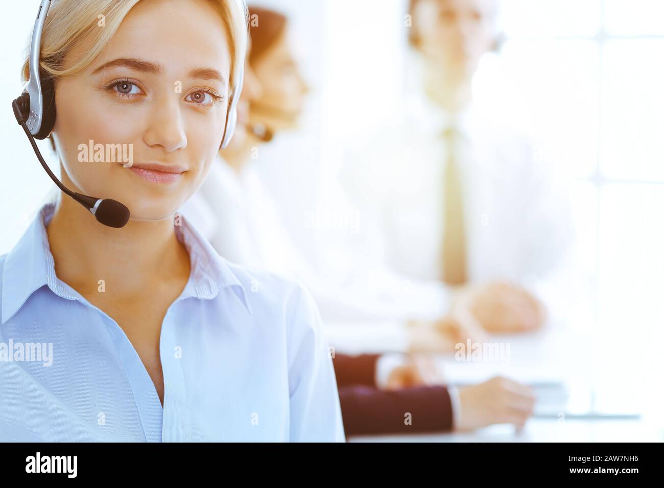 Group of diverse phone operators at work in sunny office. Handsome ...