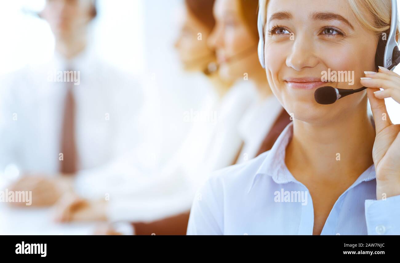 Group of diverse phone operators at work in sunny office. Handsome ...