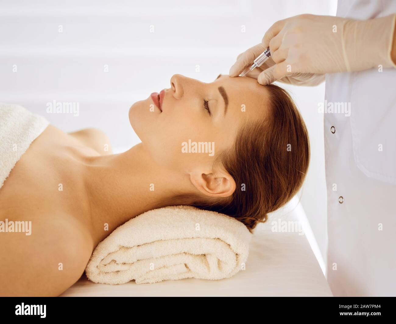 Beautiful woman receiving beauty injections with closed eyes ...