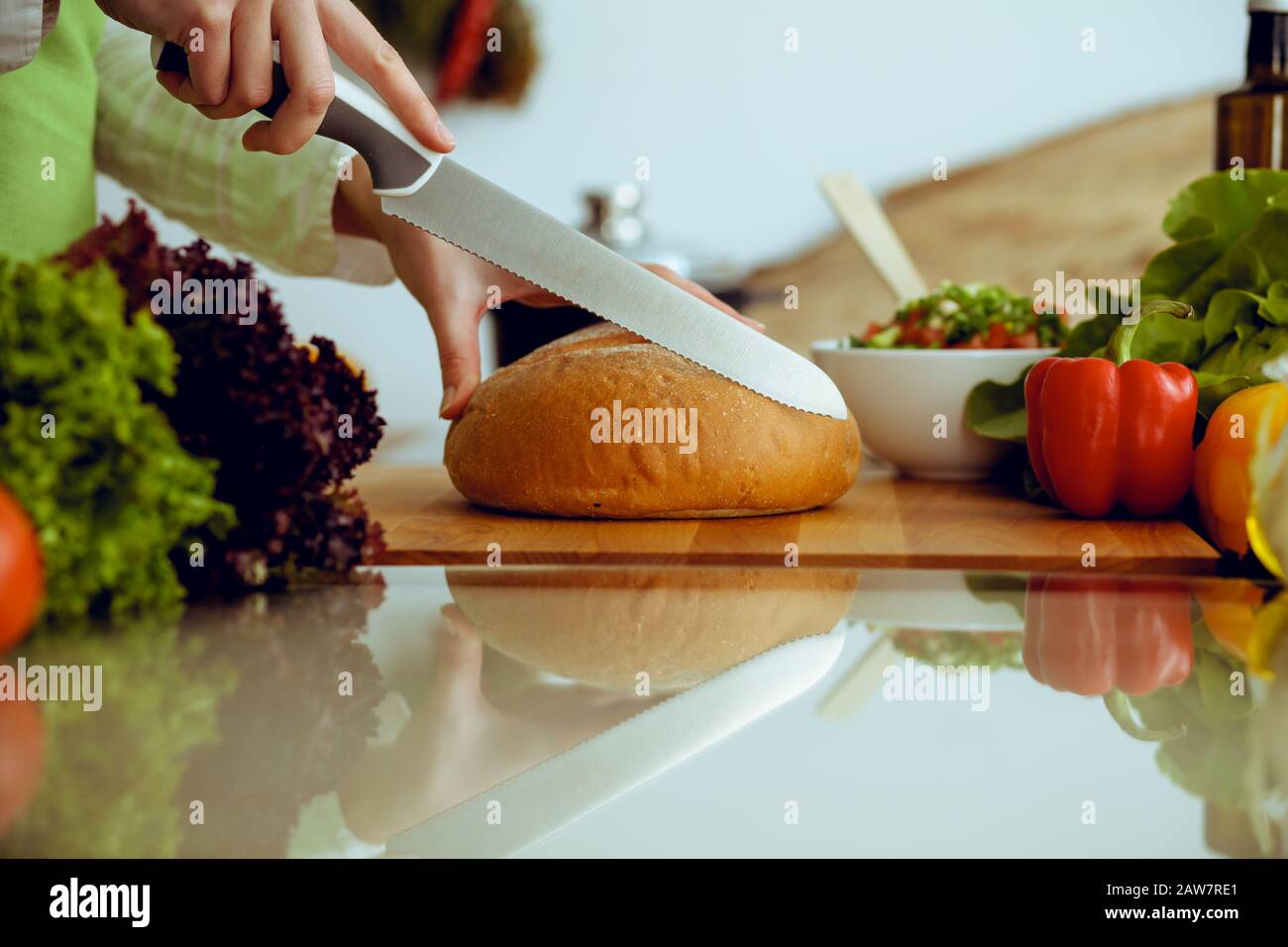 Unknown human hands cooking in kitchen. Woman slicing bread. Healthy ...