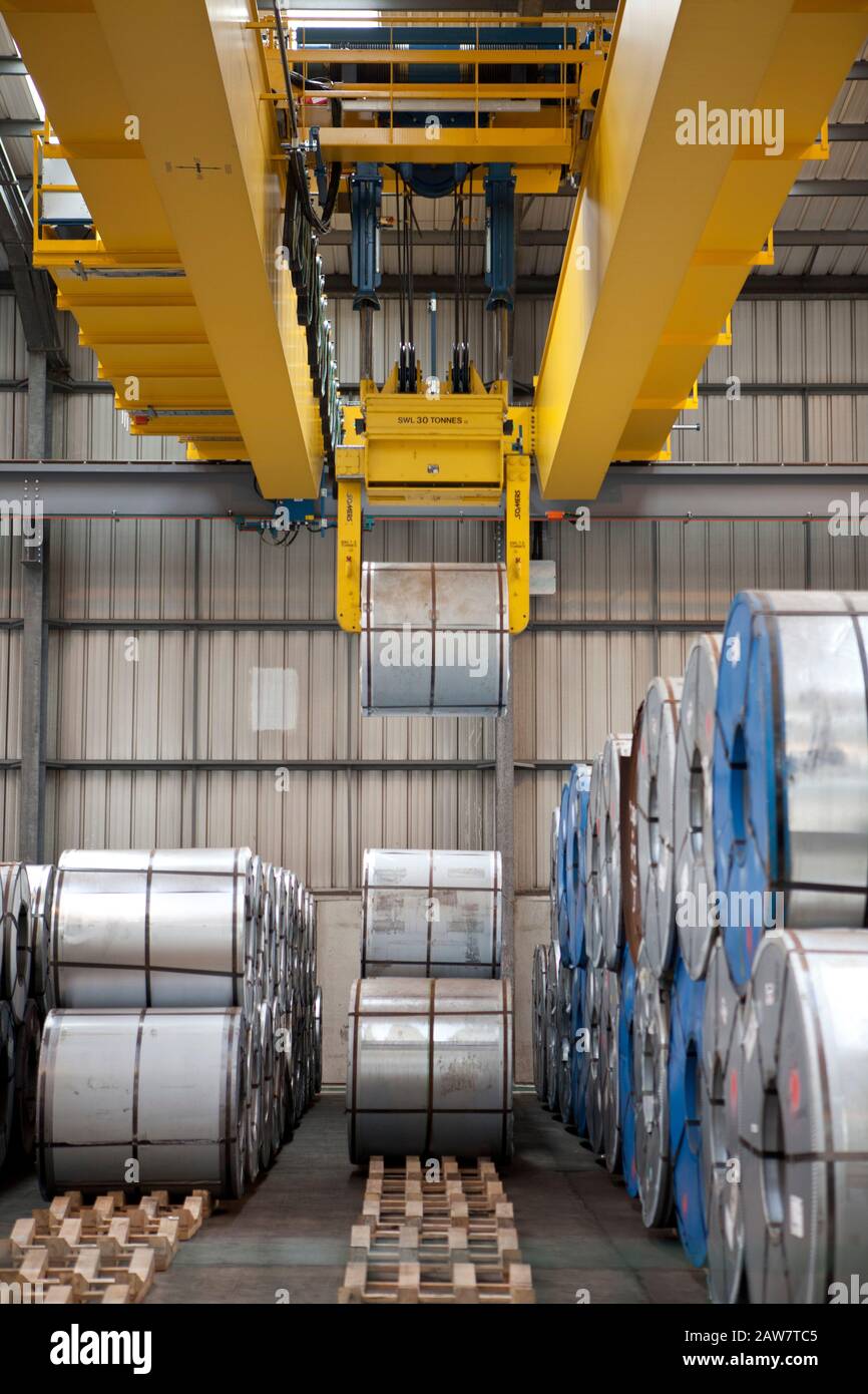 Warehouse crane lifting Steel rolls Stock Photo - Alamy