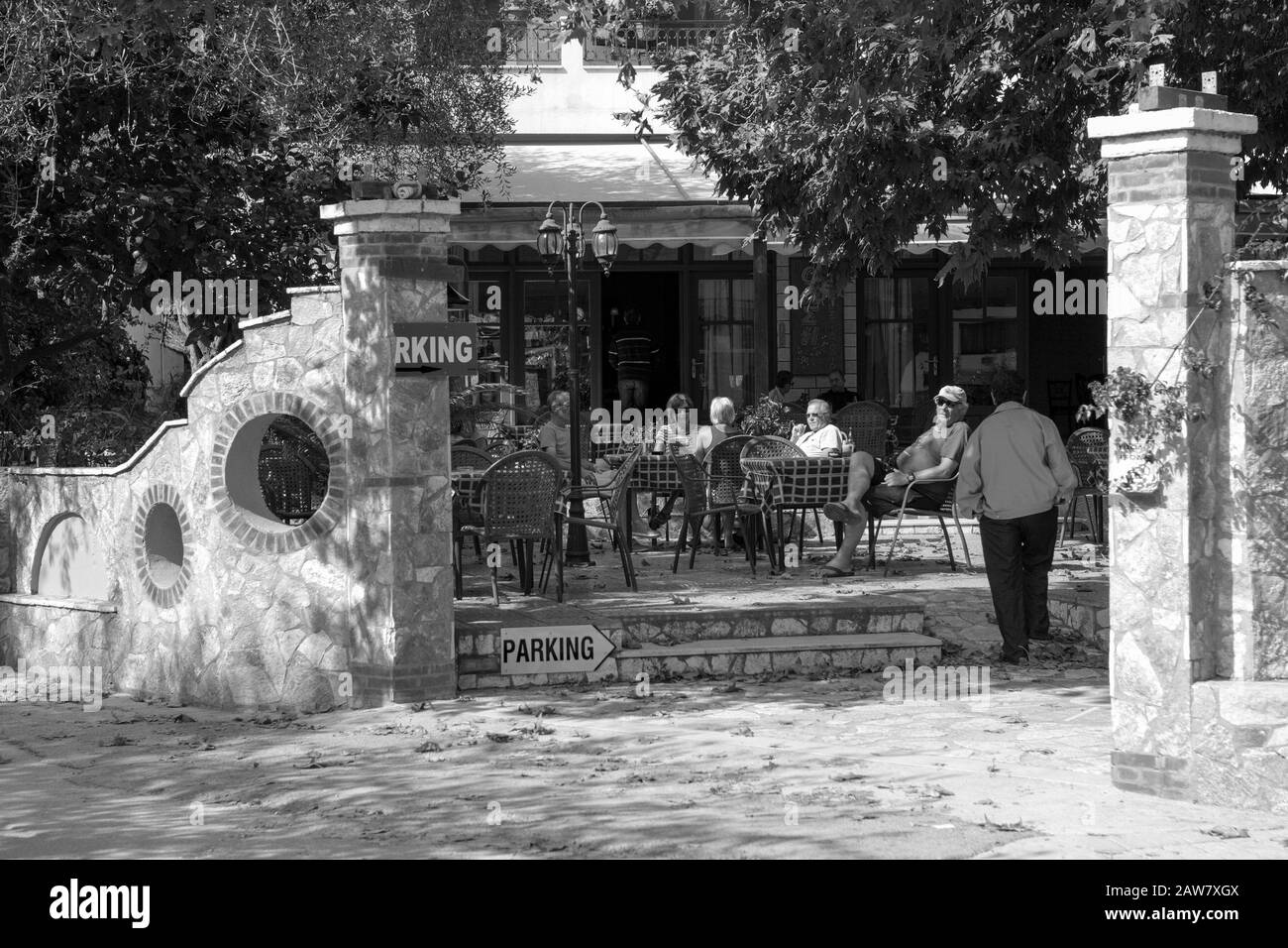 Tourists seated at a table in the town of Anthousa in Parga, all ...