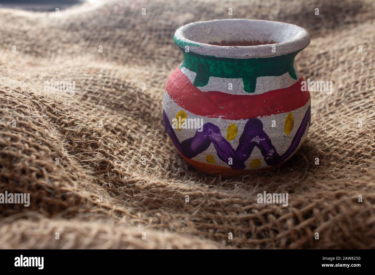 Handcrafted earthen pot over a sack bag. Clay vase made out of mud on ...
