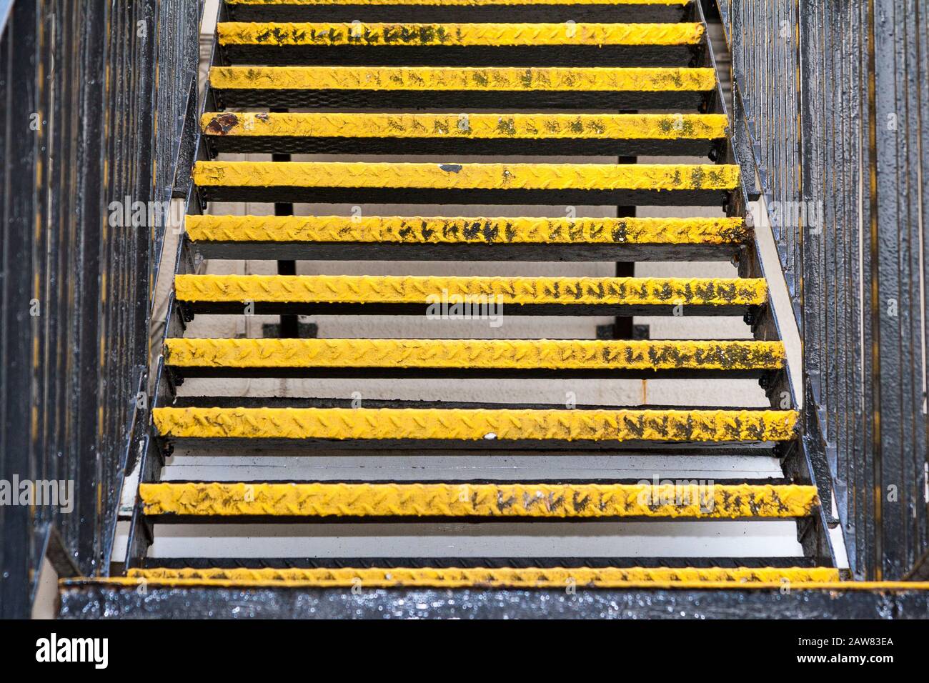 yellow painted metal fire exit steps up close Stock Photo - Alamy